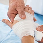 Person Wrapping Bandage To Patient | Heart and Health Medical